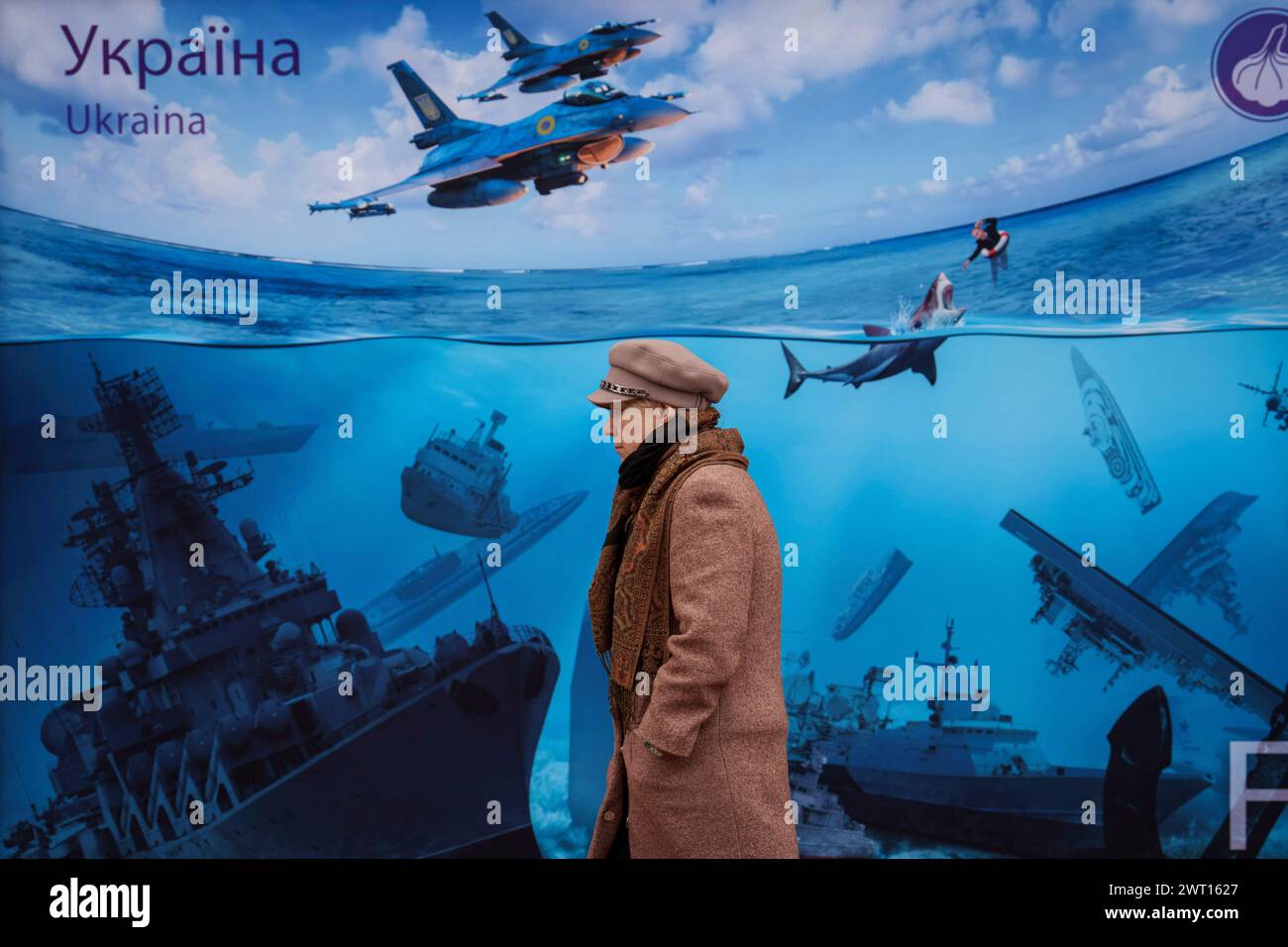 A woman walks by a poster of a Ukrainian postal stamp showing sunken ...