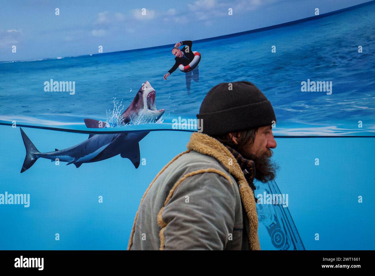A man walks by a poster of a Ukrainian postal stamp showing sunken ...