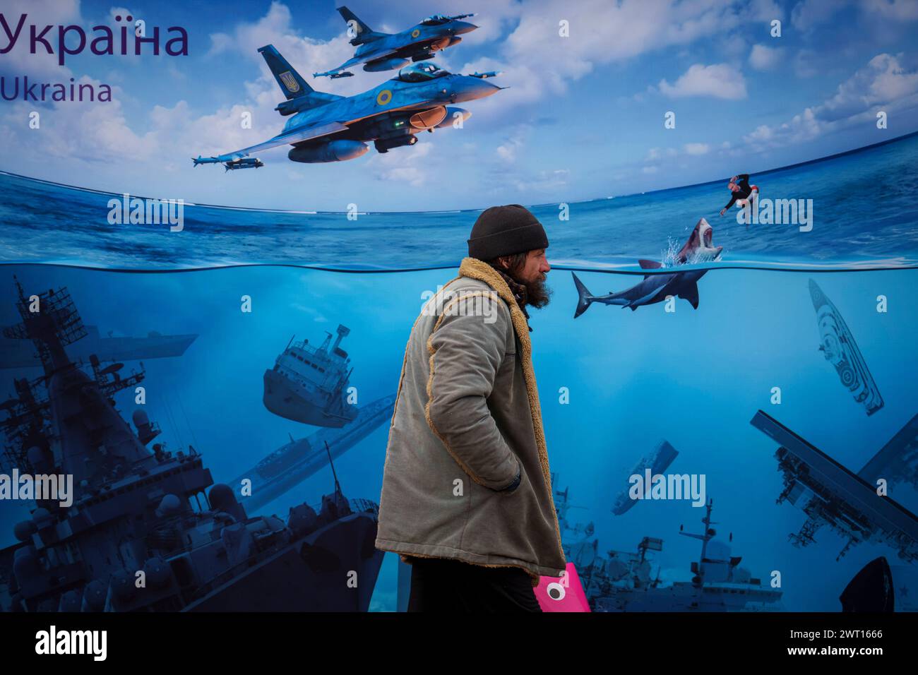 A man walks by a poster of a Ukrainian postal stamp showing sunken ...