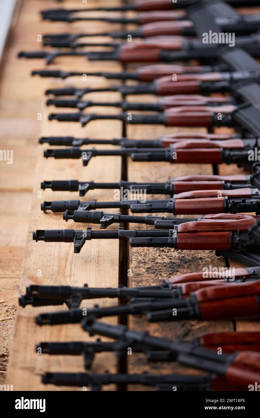 Many Kalashnikov rifles on a table at a shooting range. Big pile of ...