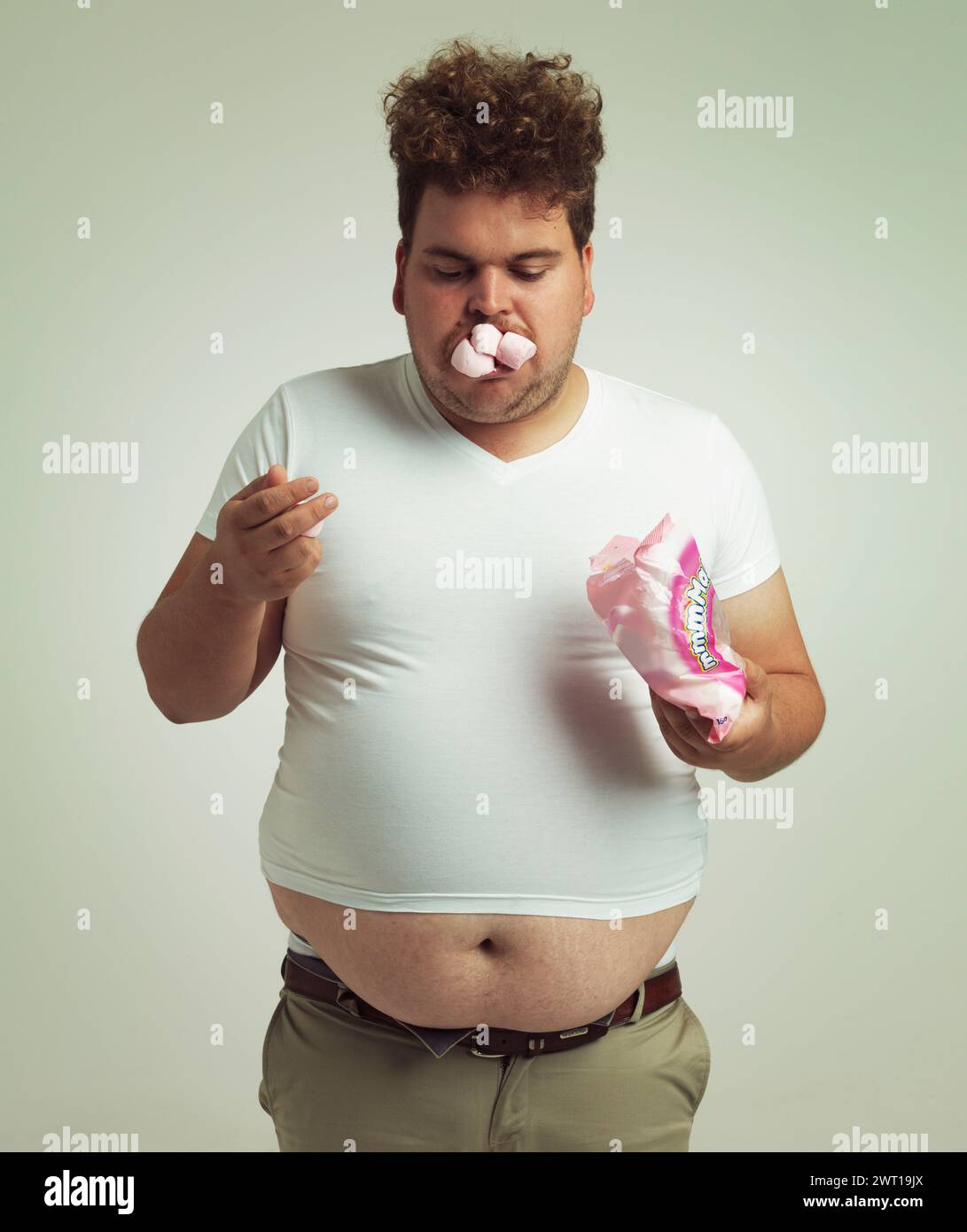 Obesity, weight gain and humor for man in studio with marshmallow for ...
