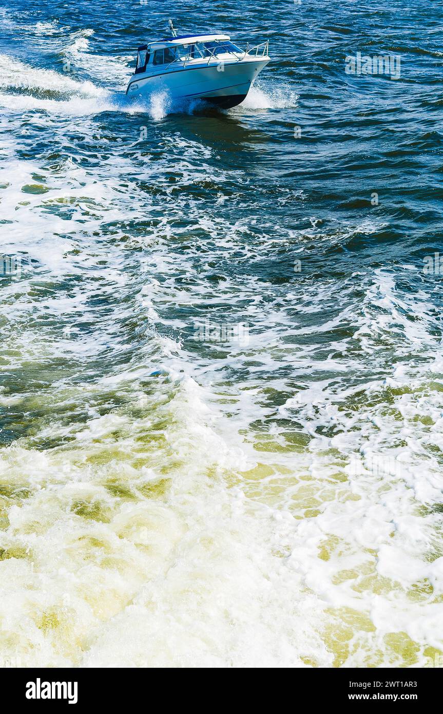 A motorboat is seen in the middle of a body of water, moving through ...