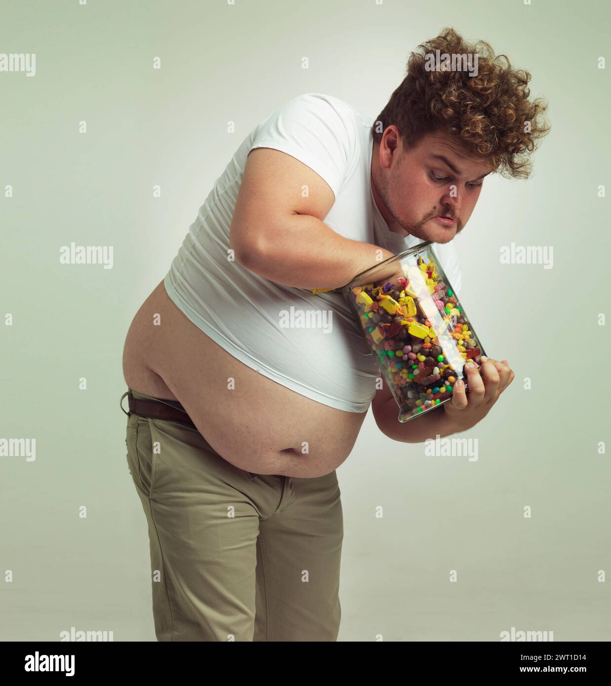 Candy, sweets jar and man in studio for eating snacks, junk food and ...