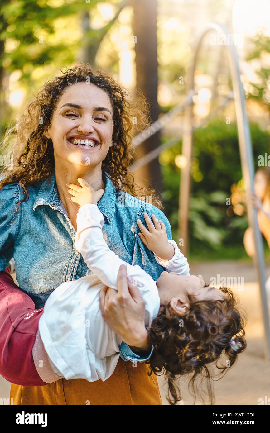 A Cheerful Mother Spins Her Laughing Daughter At The Park A Candid 0934