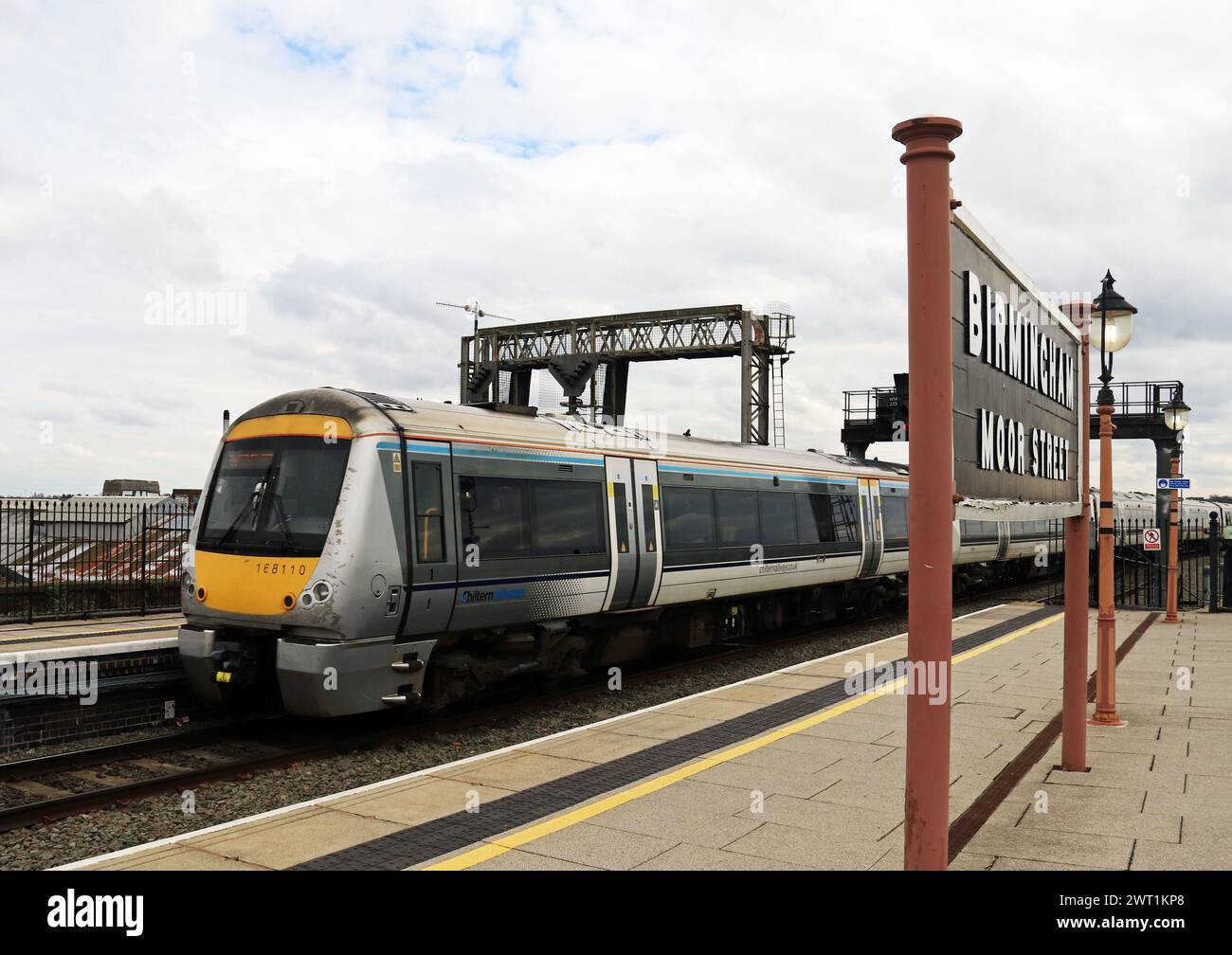 A Chiltern train passing an old wooden sign departs Birmingham Moor ...