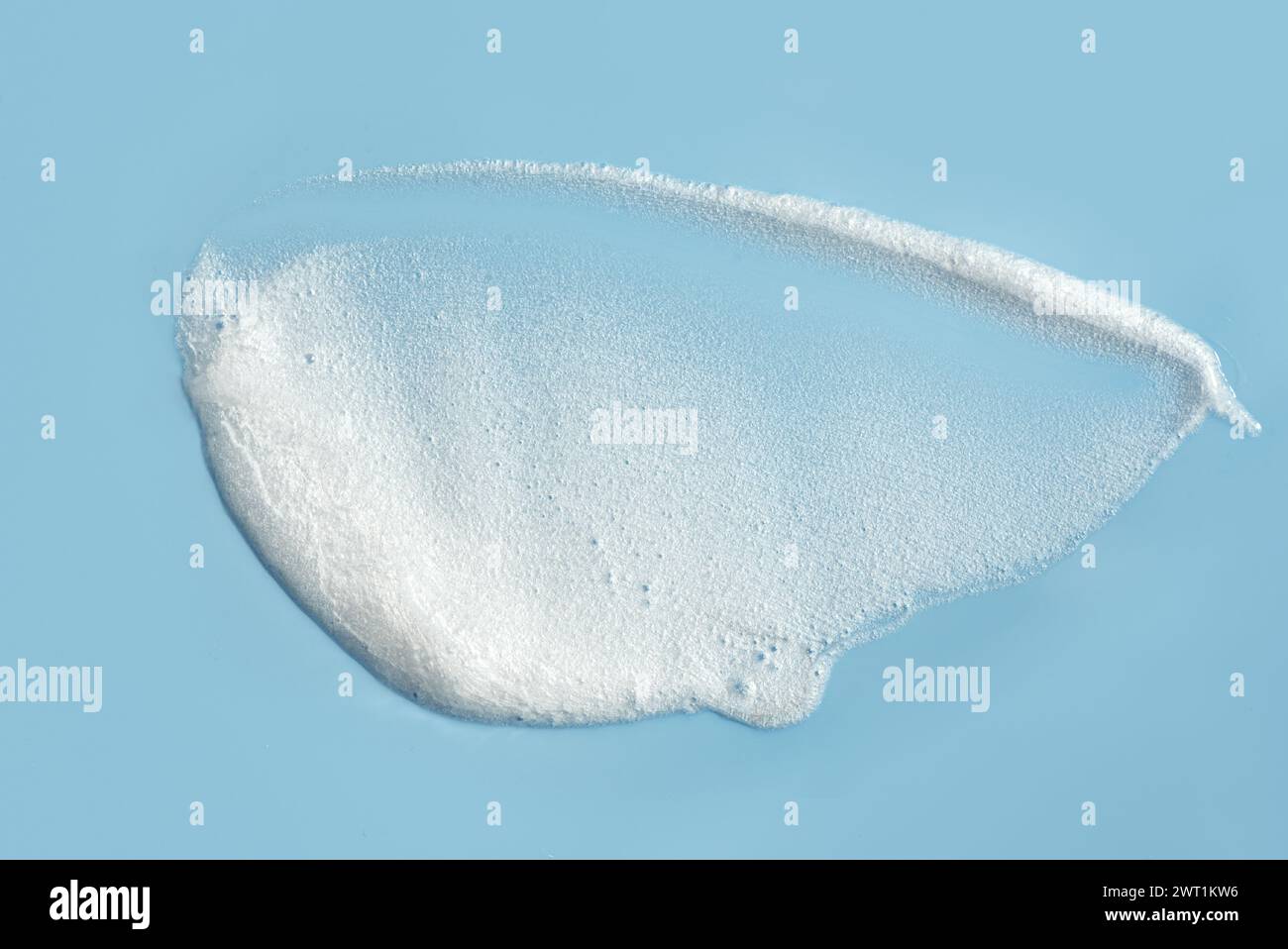 Face cleansing mousse sample. White cleanser foam bubbles on blue ...