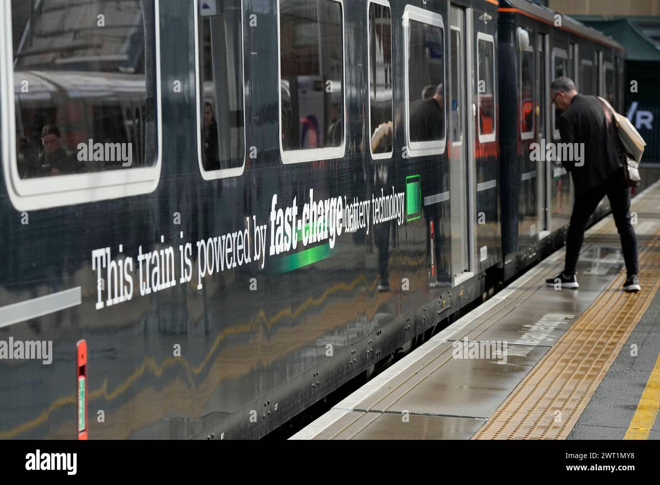 People board a fast charge battery powered trial train at West Ealing ...
