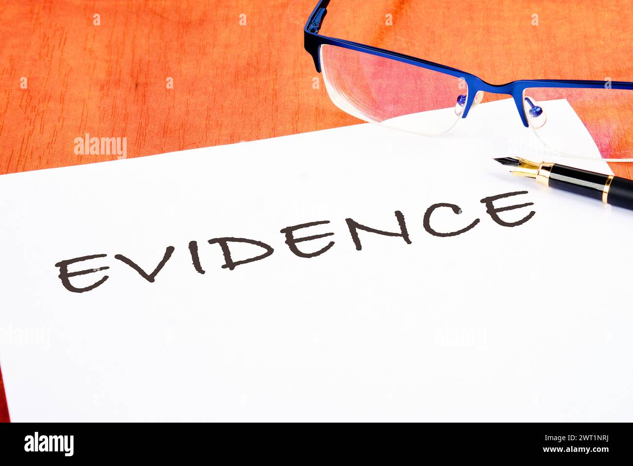 Word Evidence written on a white piece of paper on the table next to ...