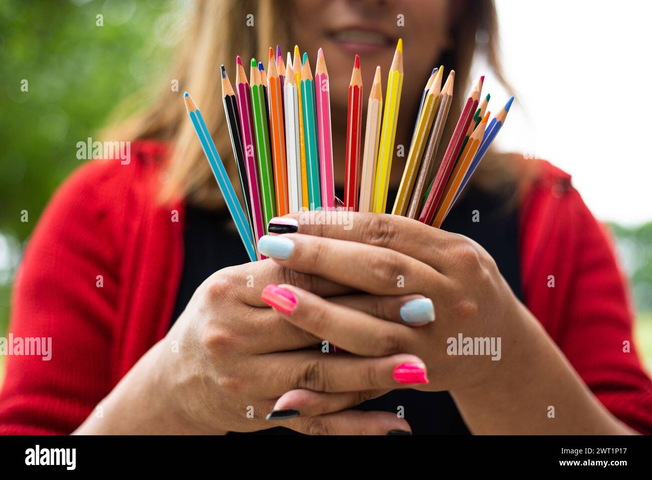 A hand holding a bunch of colored pencils Stock Photo - Alamy