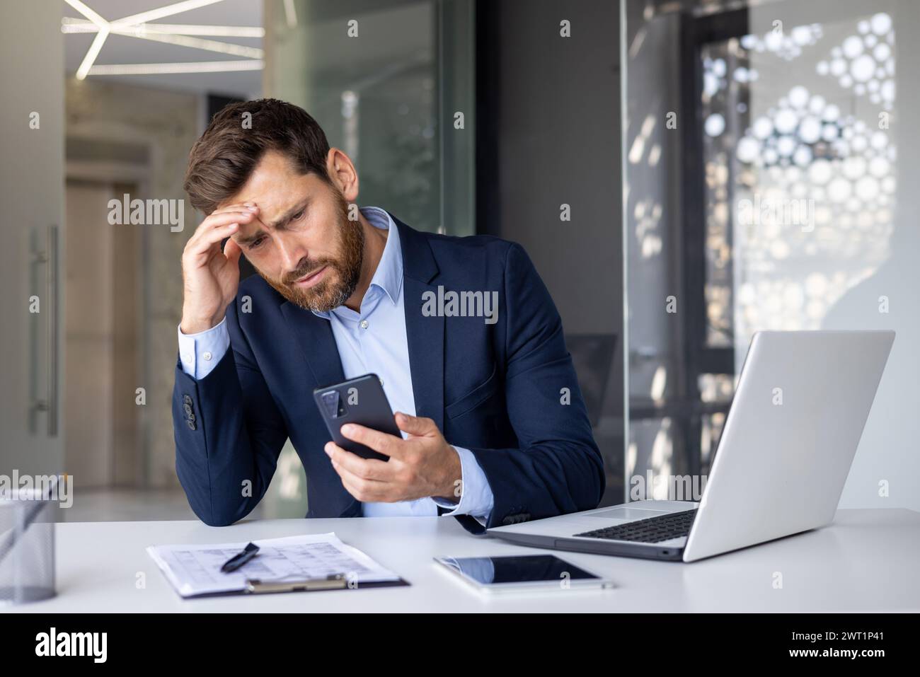 Shocked young man businessman, lawyer, banker sitting in office at desk ...