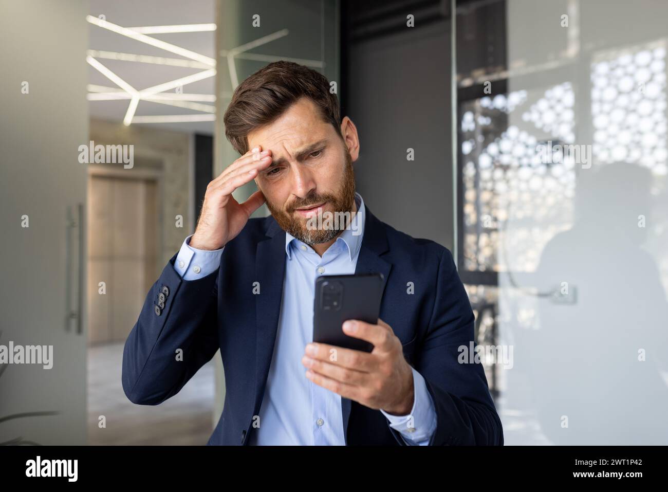 Close-up photo of a shocked man standing in a suit in the office and ...