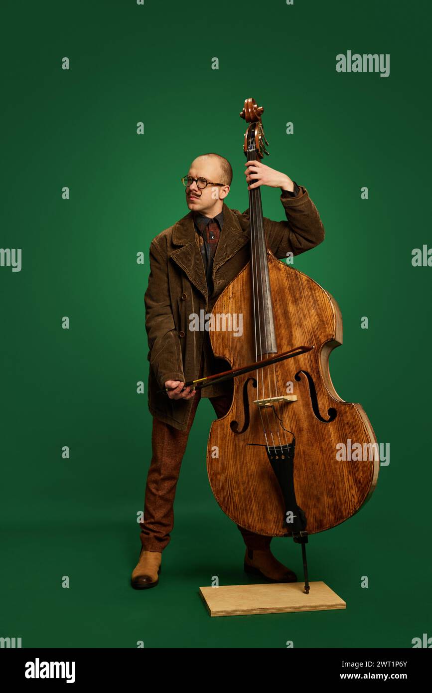 Man with stylish moustache in brown suit playing double bass against ...