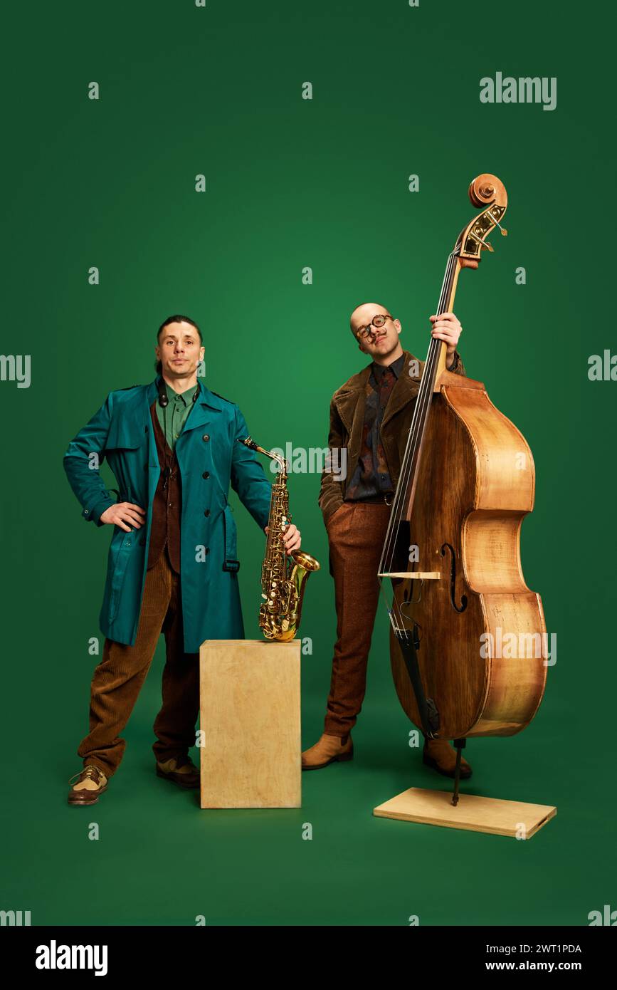 Two stylish man, musician standing with saxophone and double bass ...