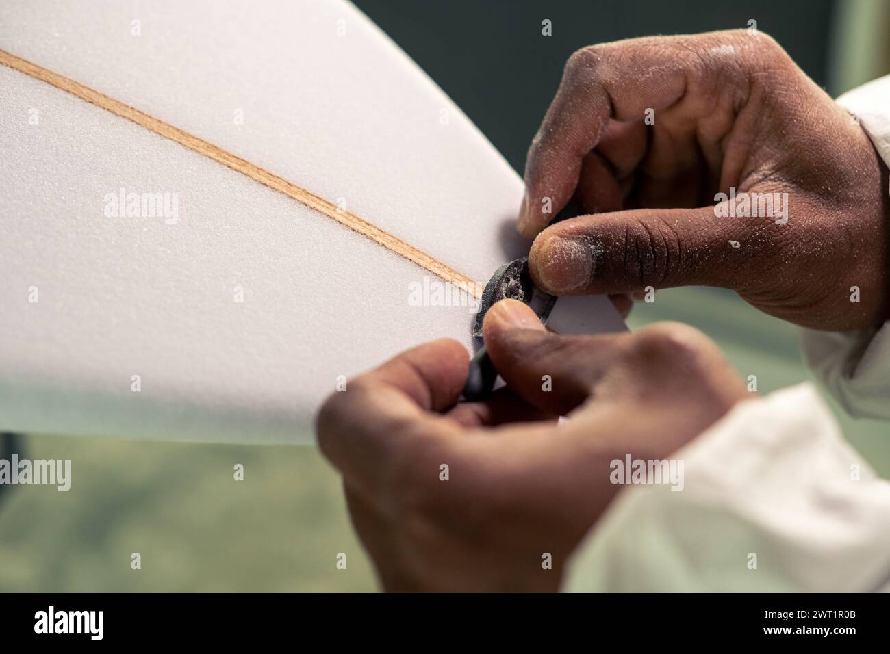 Surfboard manufacturing, Shaper working on board details. Concept of ...