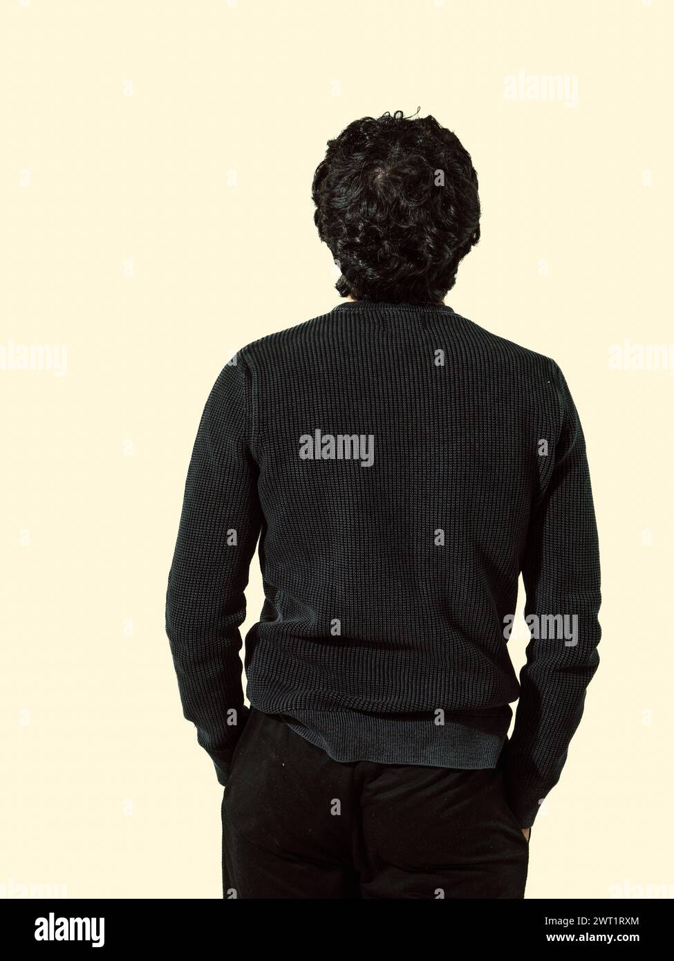 In this photo, a man is seen standing with his back facing the camera ...