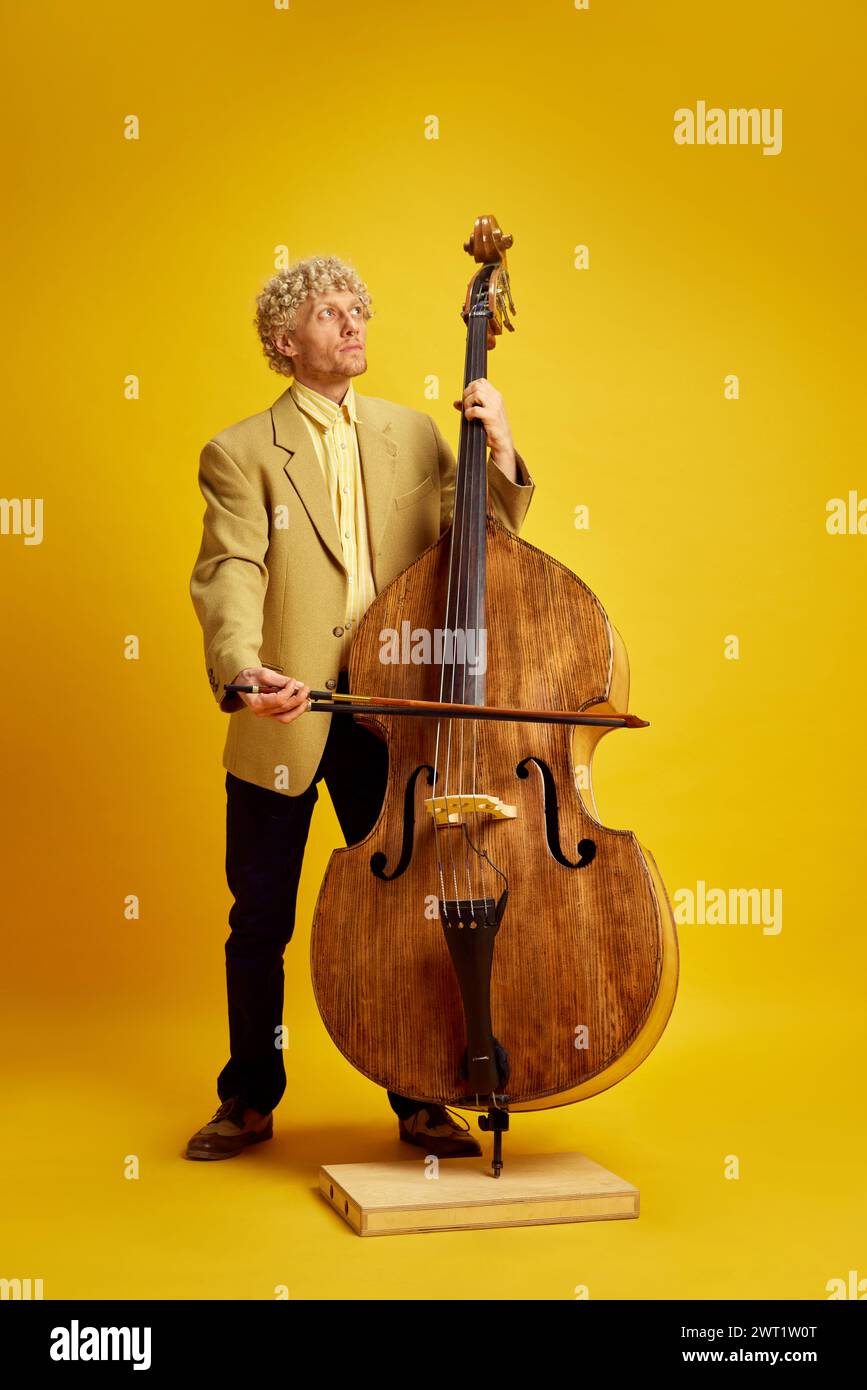 Stylish man in suit paying double bass, making classical music live ...