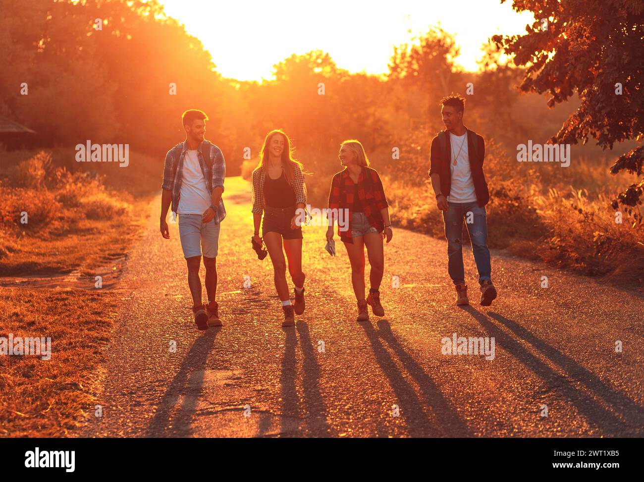 Group of four friends having fun hiking through countryside together on ...