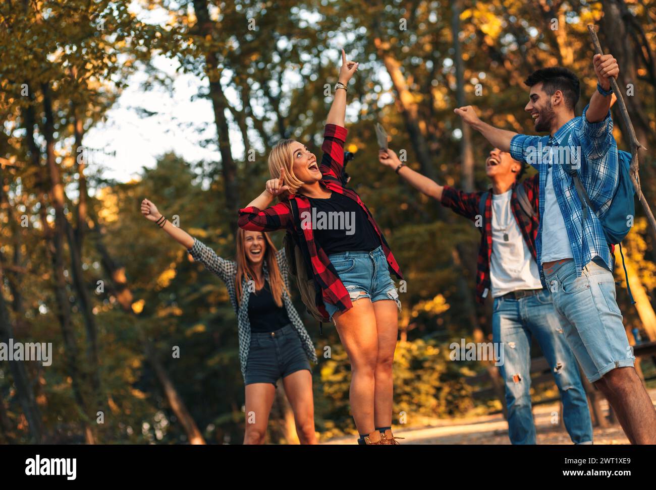 Group of four friends having fun hiking through forest together Stock ...