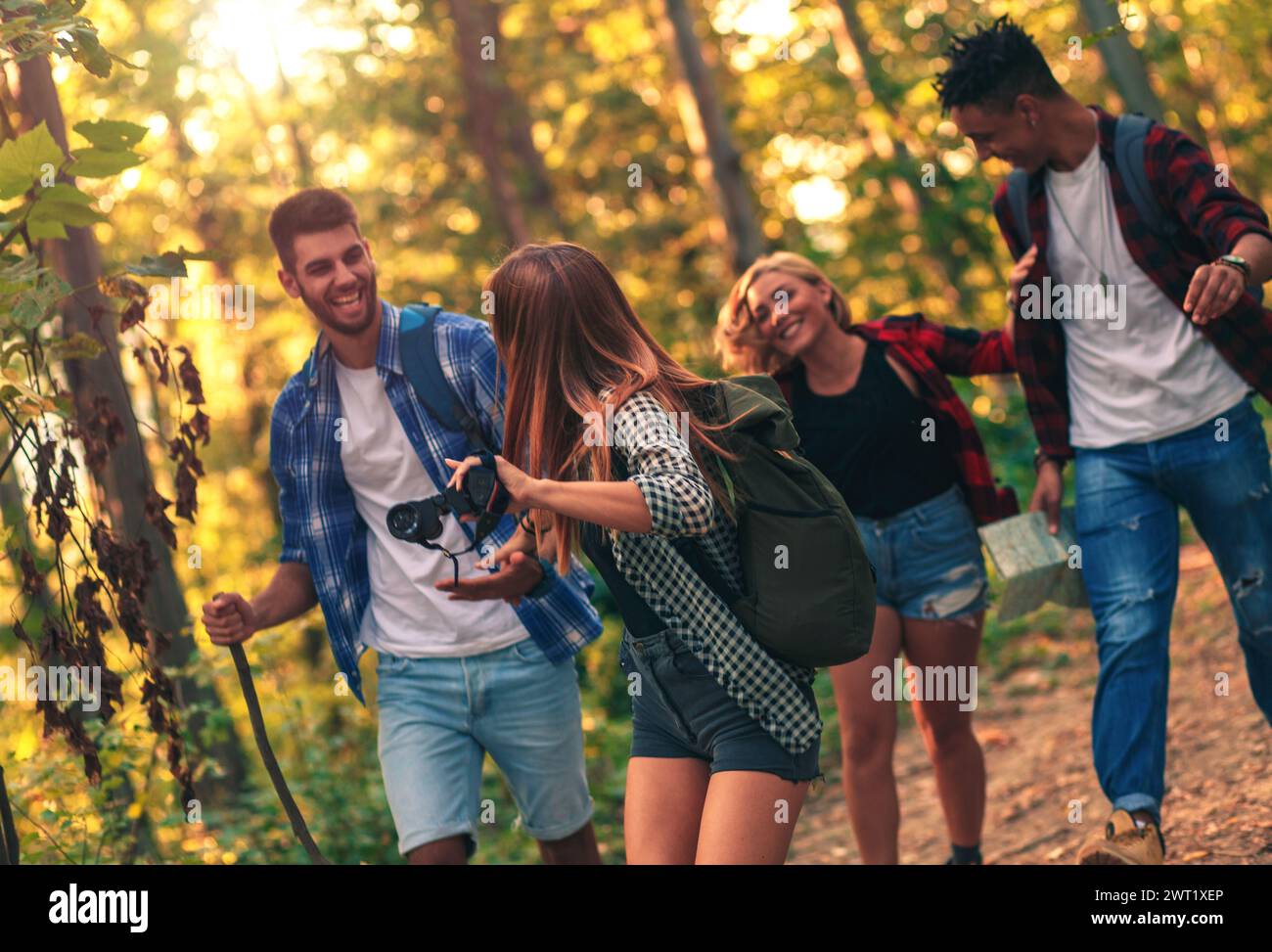 Group of four friends having fun hiking through forest together Stock ...