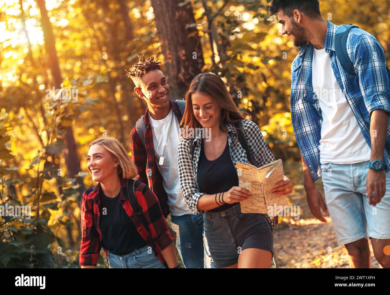 Group of four friends having fun hiking through forest together Stock ...