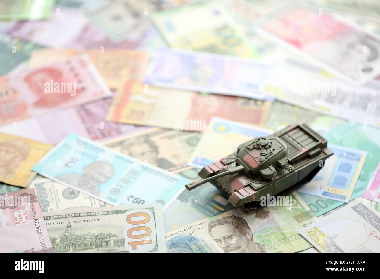Small green tank on many banknotes of different currency. Background of ...