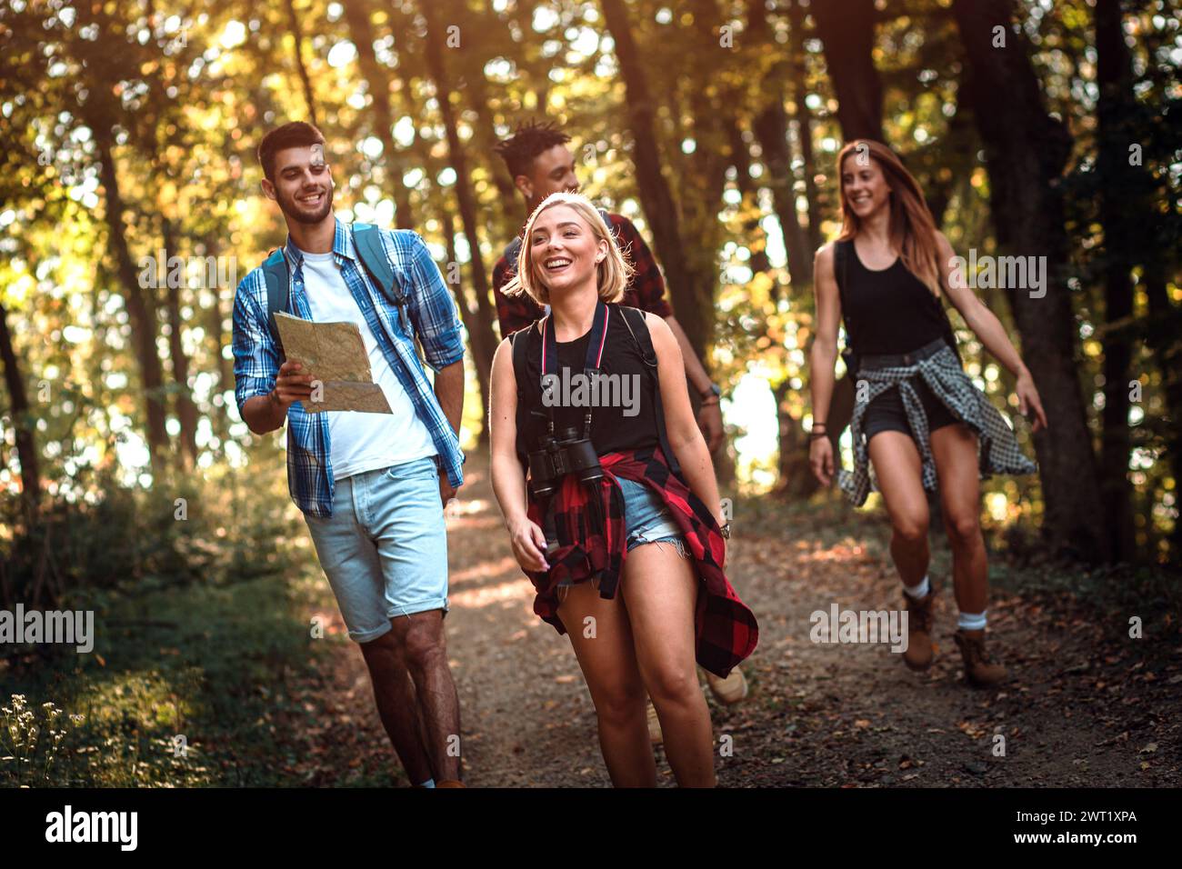 Group of four friends having fun hiking through forest together Stock ...