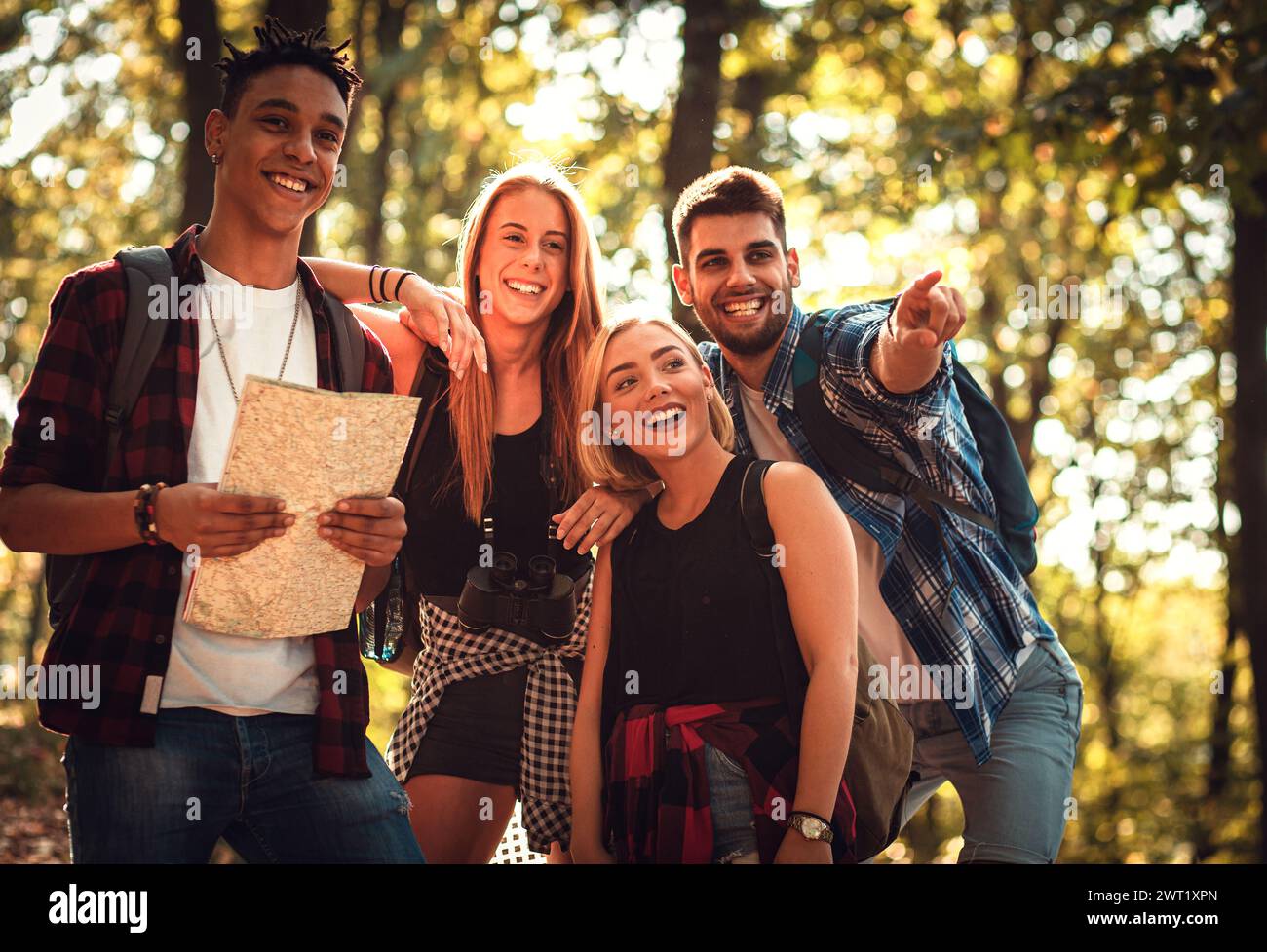 Group of four friends having fun hiking through forest together Stock ...