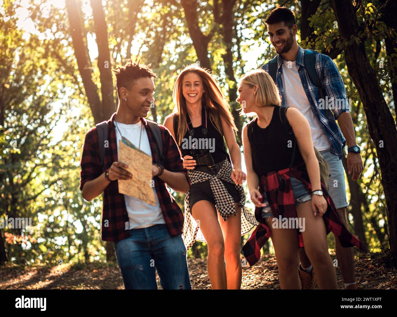 Group of four friends having fun hiking through forest together Stock ...