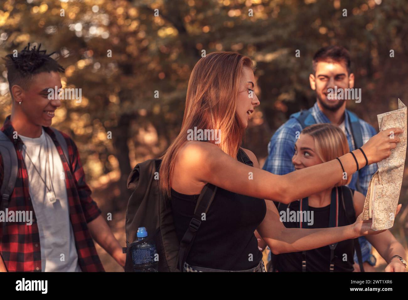 Group of four friends having fun hiking through forest together Stock ...