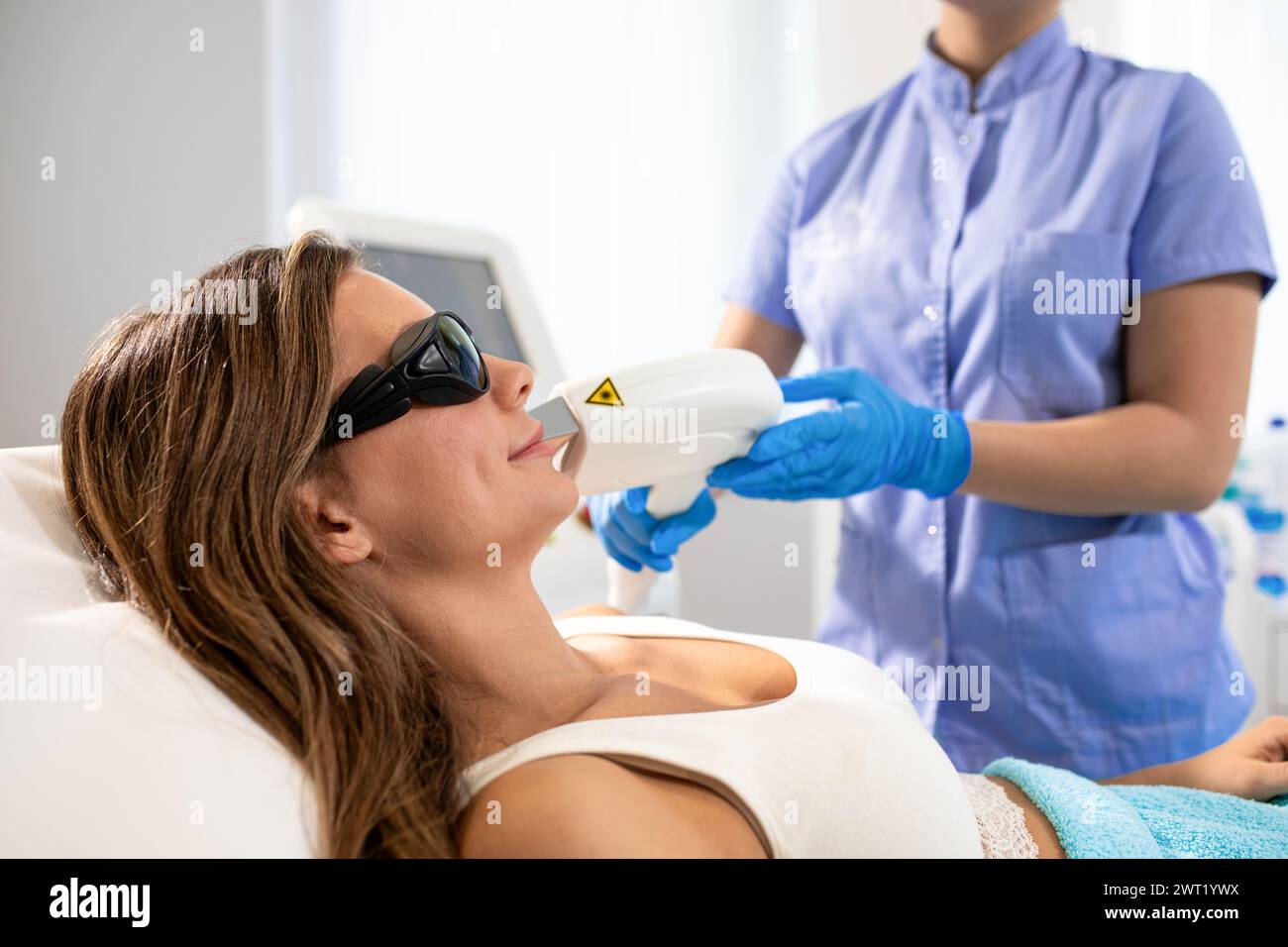 Woman in a beauty salon removes face hair with laser epilation Stock ...
