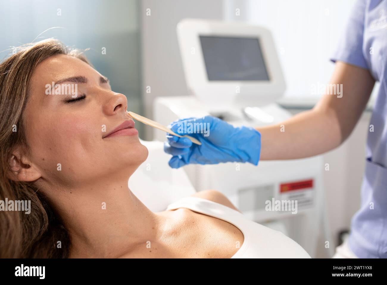 Woman in a beauty salon removes face hair with laser epilation Stock ...