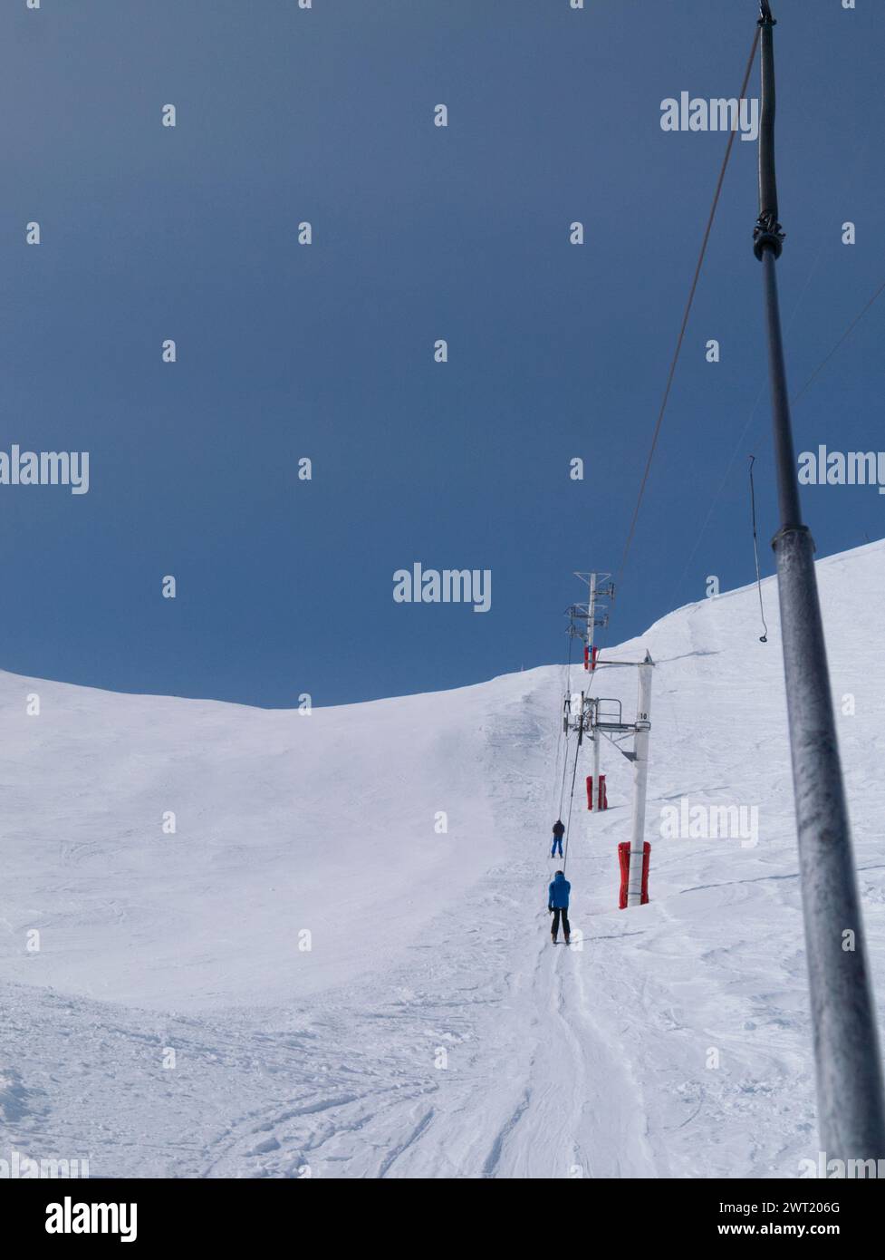 Skiers on poma ski lift next to piste, French Alps Stock Photo - Alamy