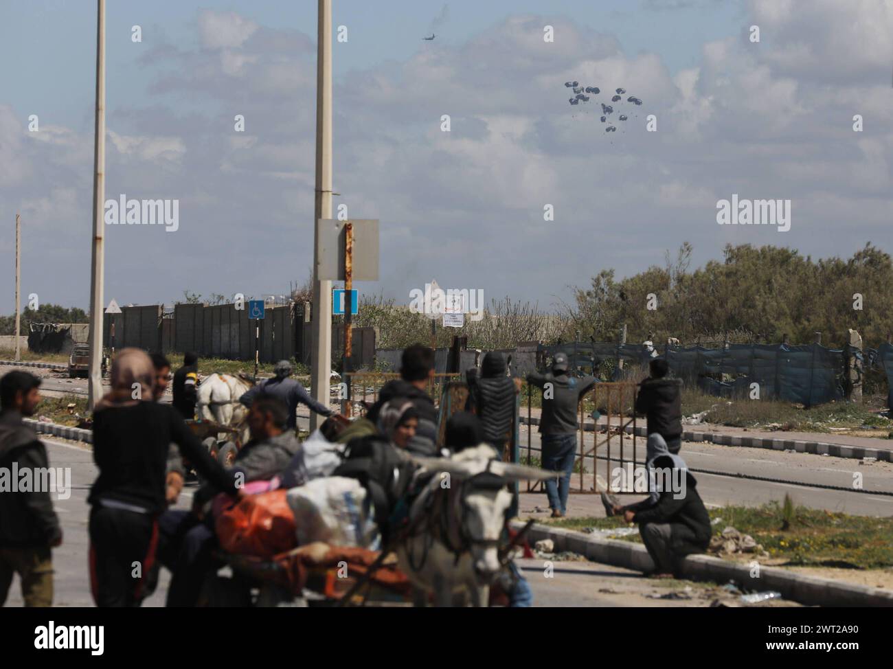 Parachutes attached to parcels of humanitarian aid are airdropped over ...