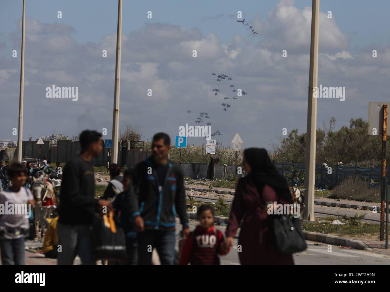 Parachutes attached to parcels of humanitarian aid are airdropped over ...