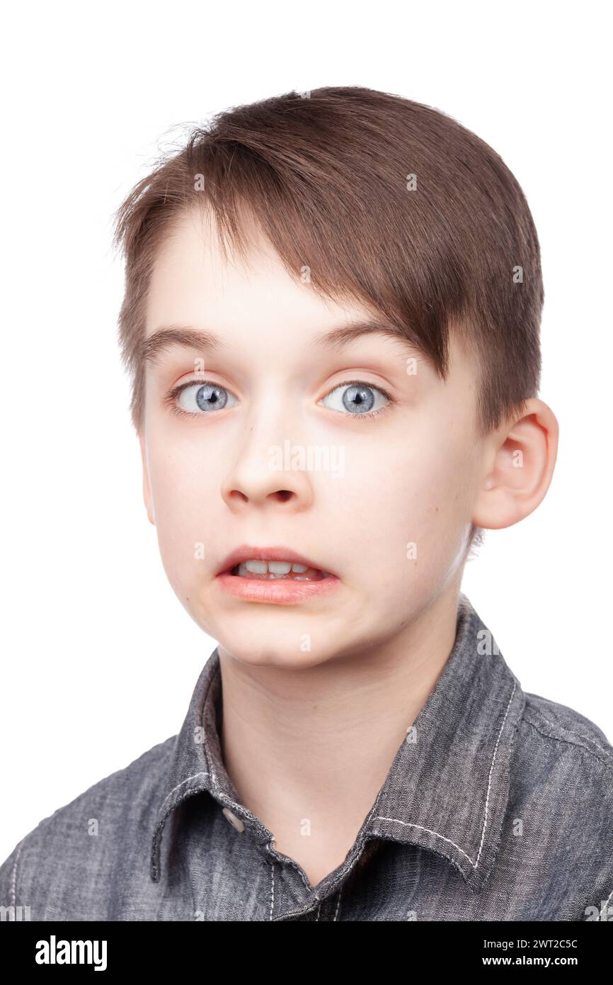 A young boy wearing denim shirt looks surprised with wide eyes. Studio ...