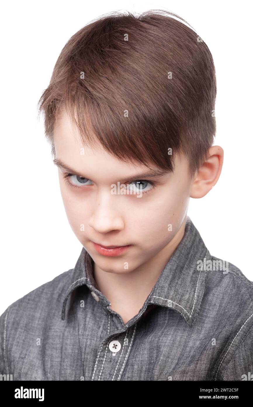 A young boy wearing denim shirt gazing intently at the camera giving a ...