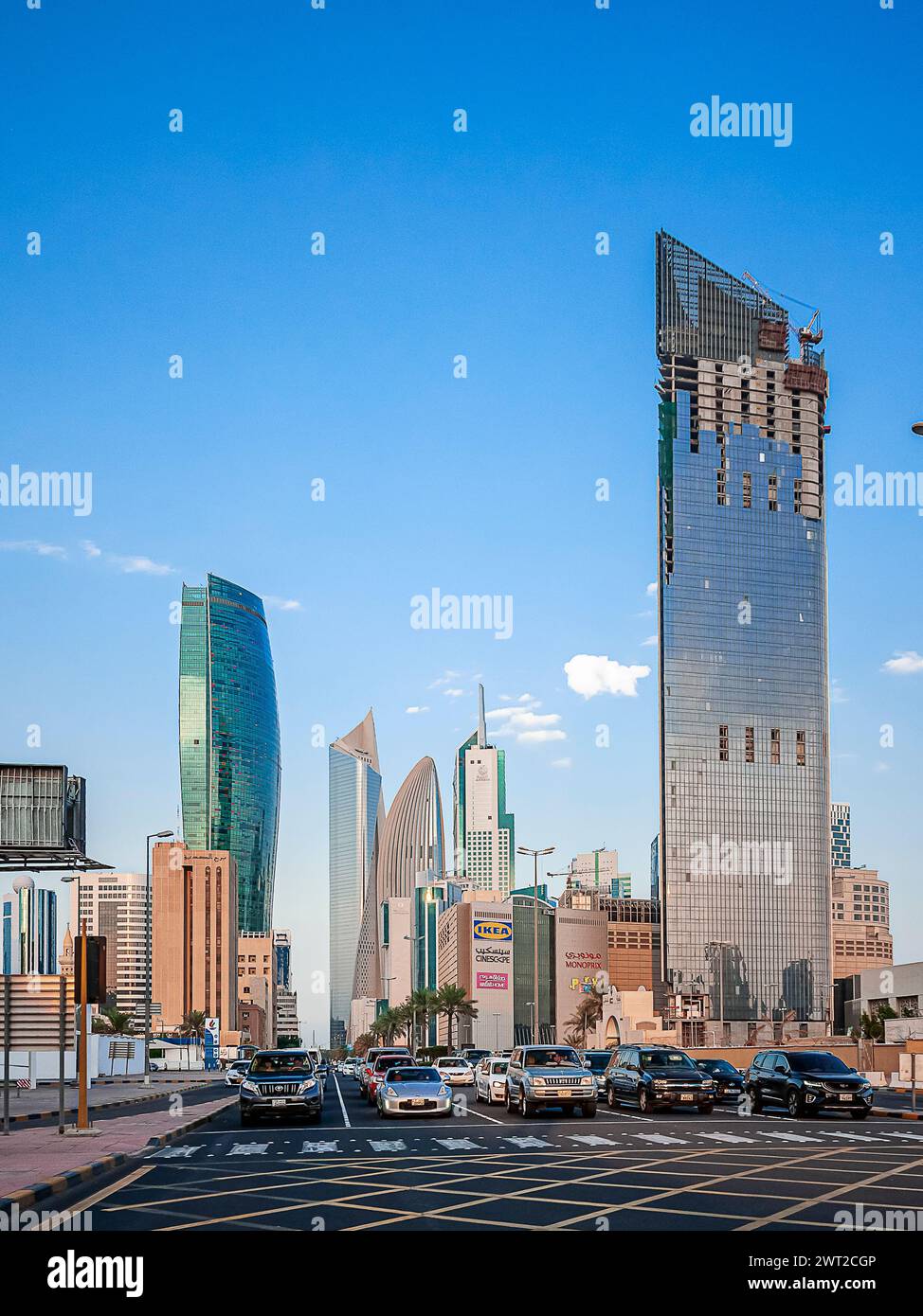 a street in Kuwait City with cars stopped at the traffic lights and ...