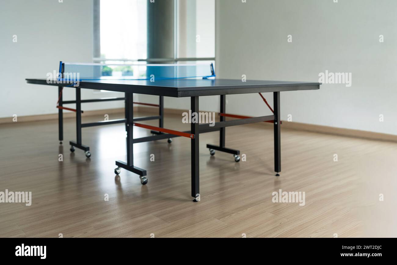 Green table tennis table with net in room Stock Photo - Alamy