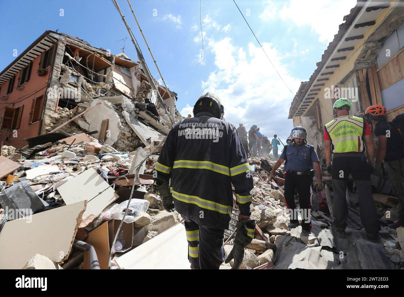 A rescue men, a fireman and a military man, on the rubble of a house ...