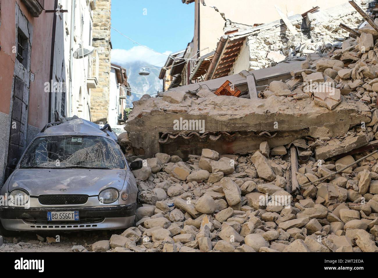 A car under the rubble of a house completely collapsed after the ...