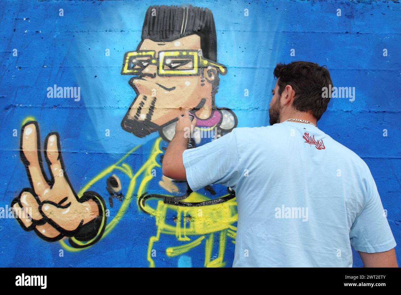 An artist while creating a mural during the Writers Reunion "Just ...