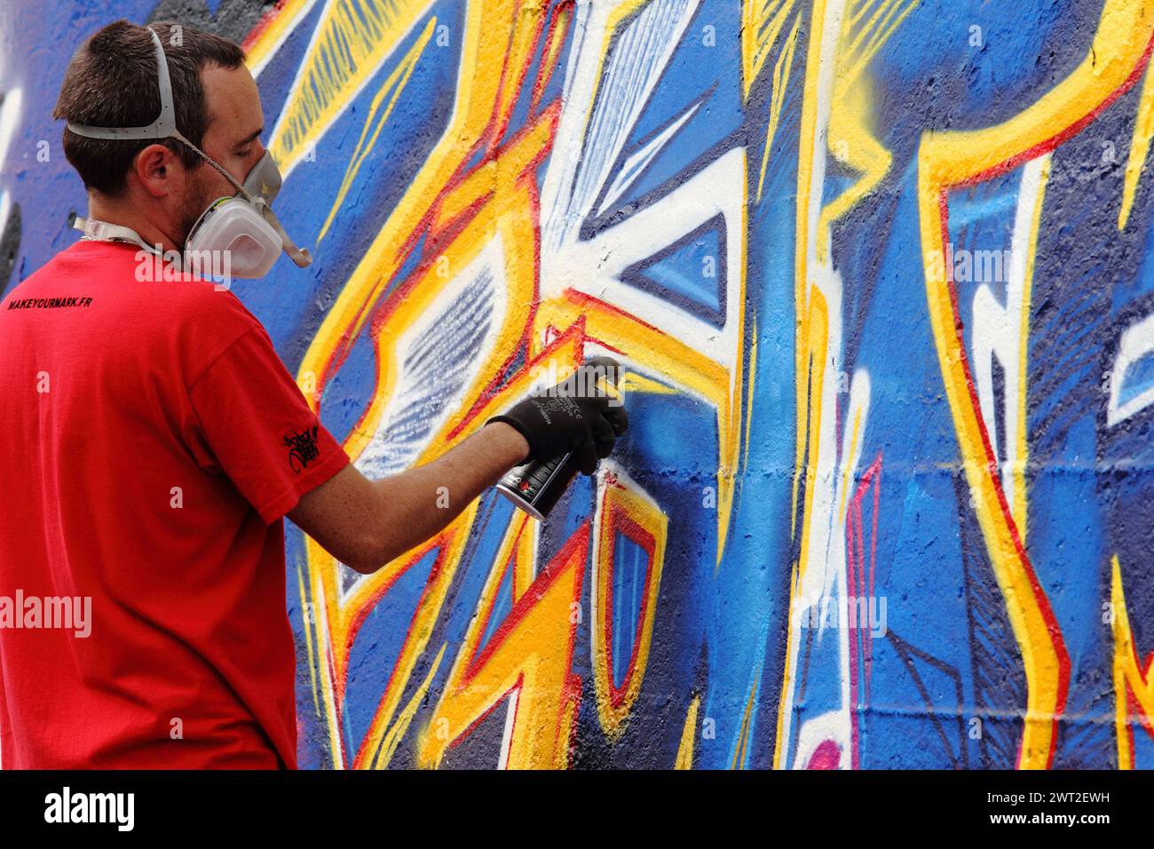 An artist while creating a mural during the Writers Reunion "Just ...
