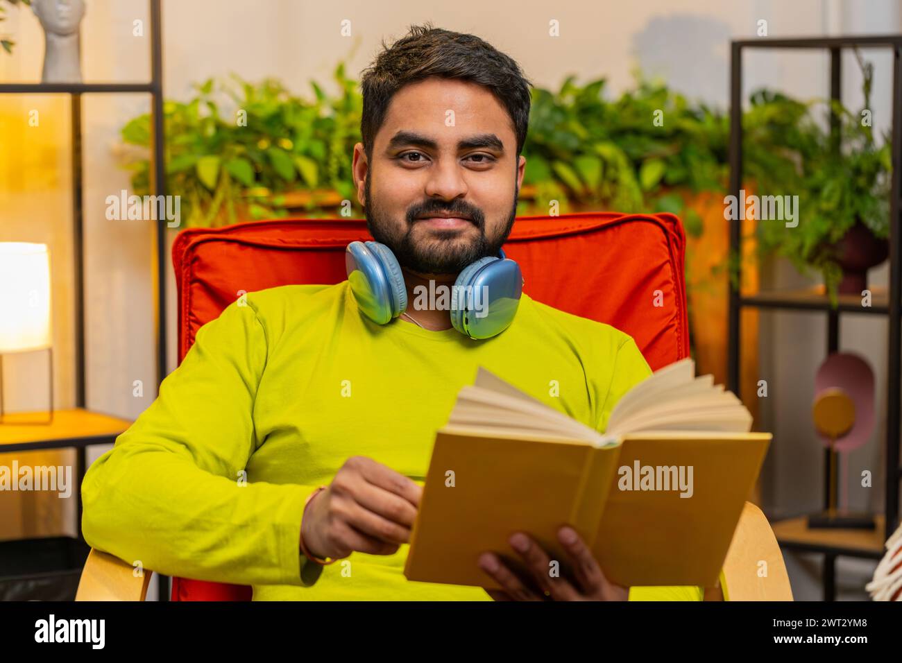 Indian man reading interesting book, turning pages smiling enjoying ...