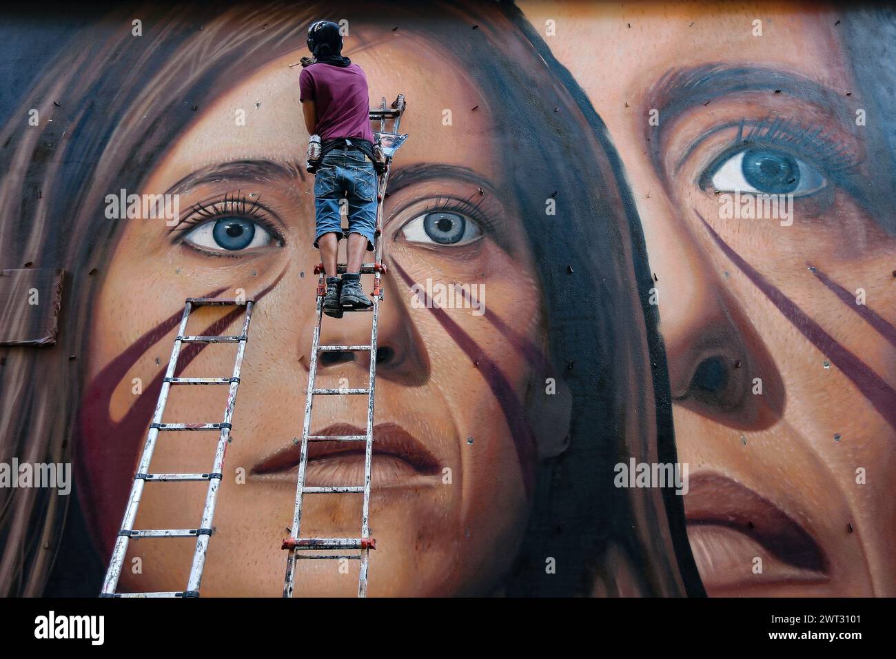 The street artist Jorit Agoch at work on a giant murales of Ilaria ...