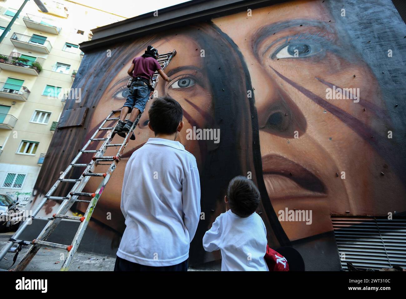 The street artist Jorit Agoch at work on a giant murales of Ilaria ...