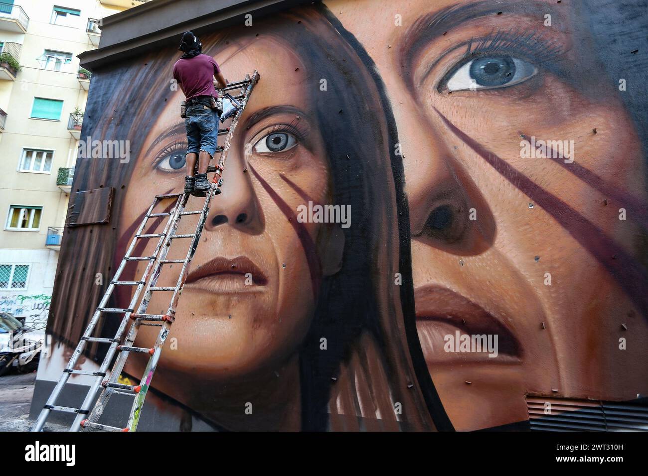 The street artist Jorit Agoch at work on a giant murales of Ilaria ...