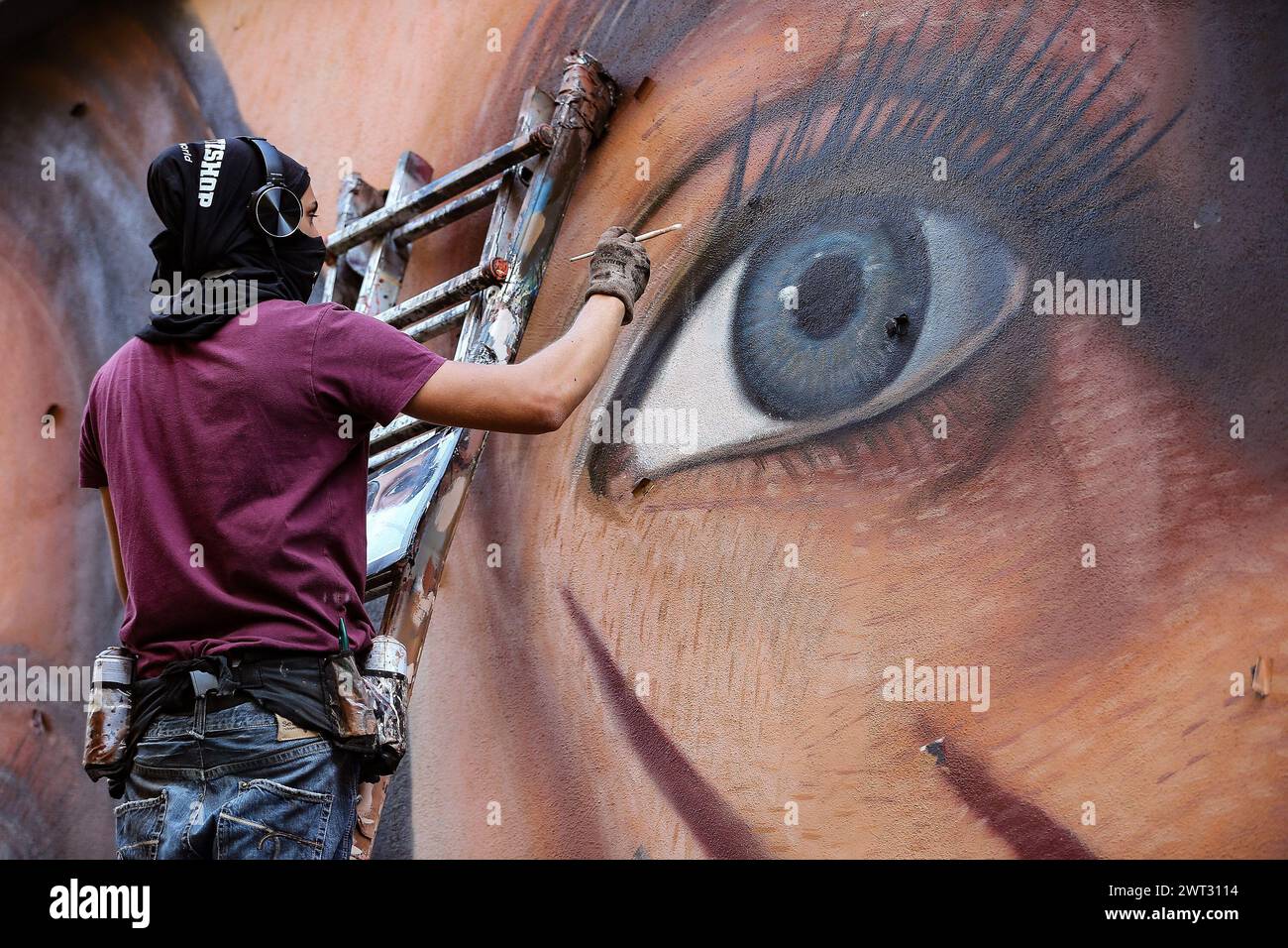 The street artist Jorit Agoch at work on a giant murales of Ilaria ...