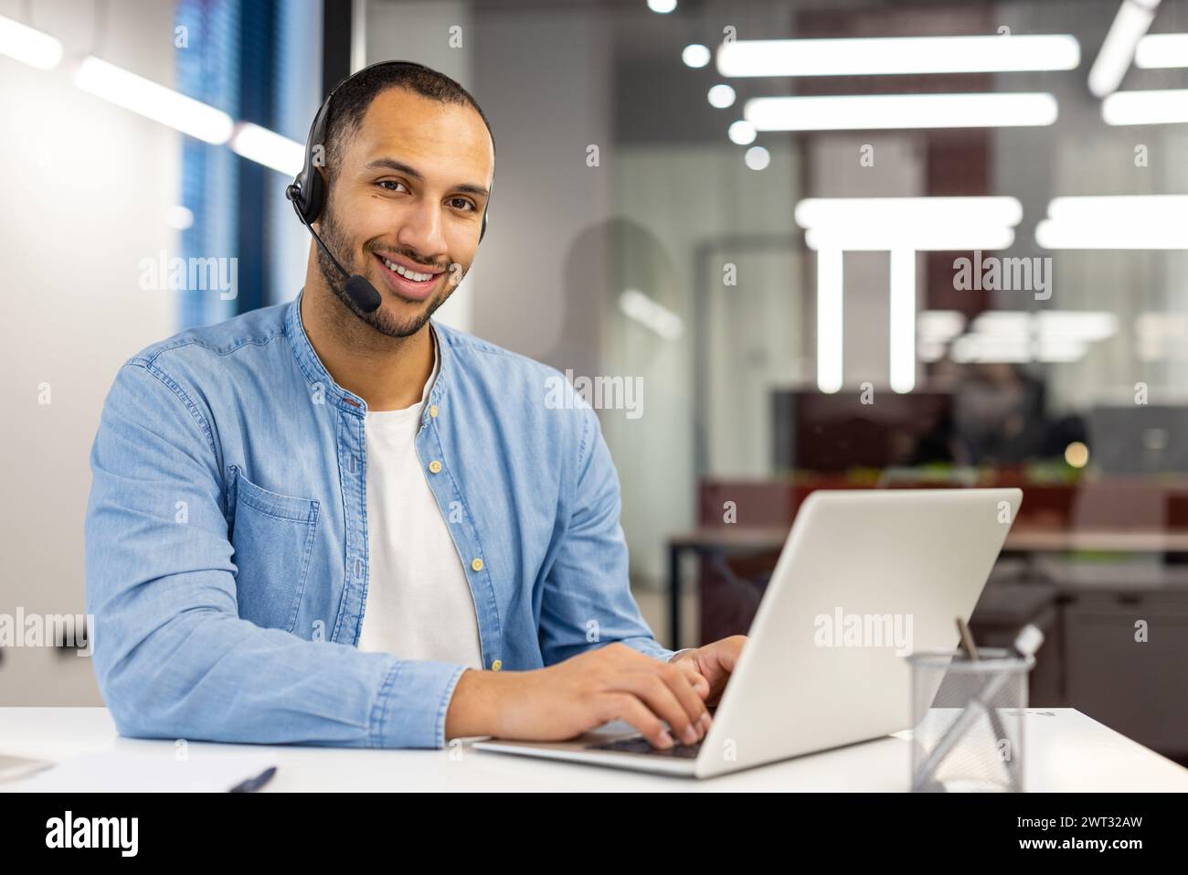 Confident male customer support agent wearing a headset while working ...