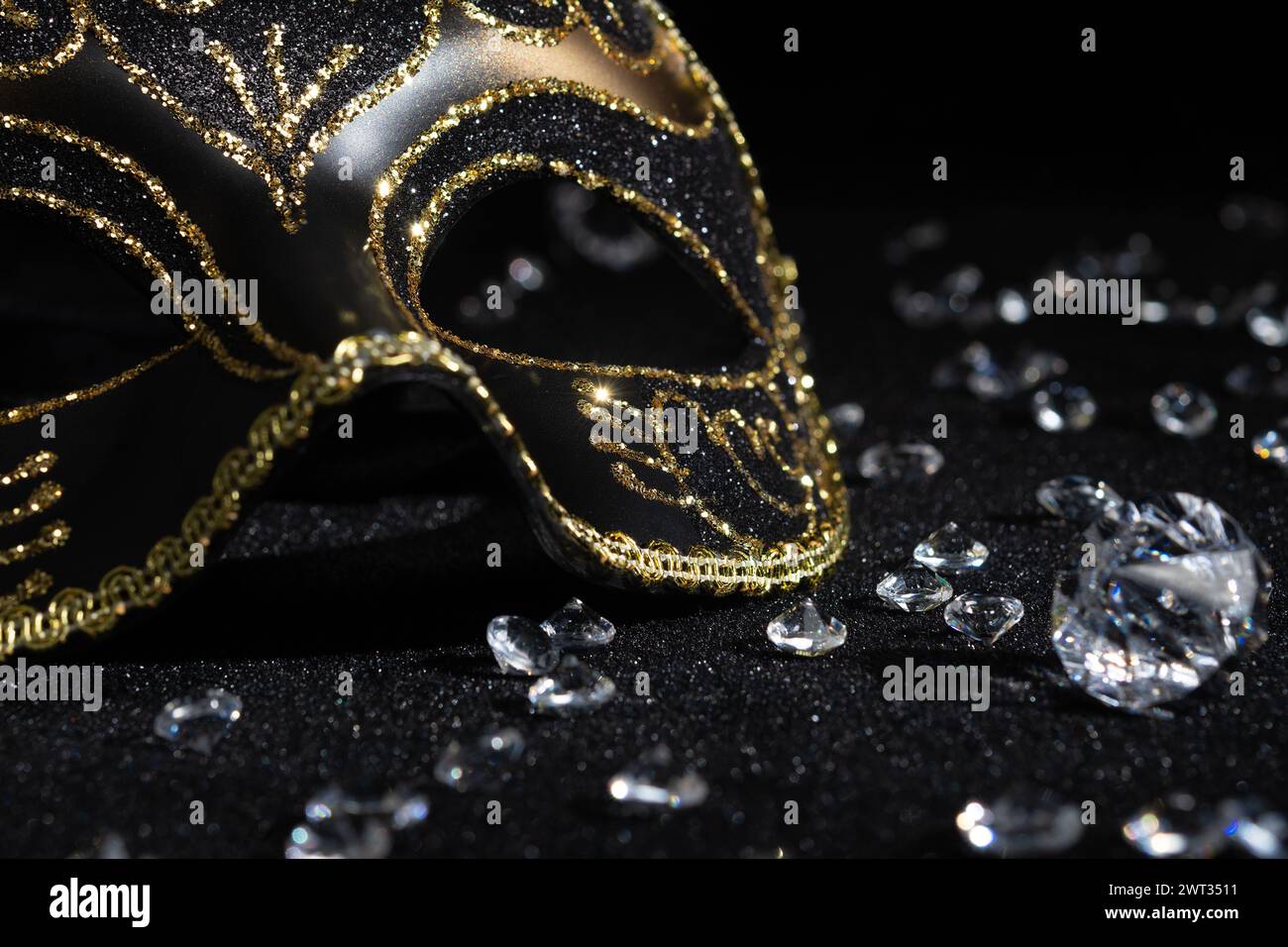Close-up view of Carnival gold mask with diamonds on black background ...