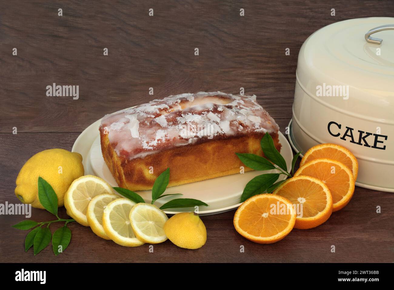Lemon and orange lemon drizzle icing cake with fresh fruit and leaves ...